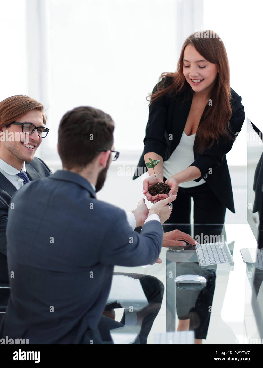 vertical photo.a happy employee is showing fresh sprout Stock Photo - Alamy