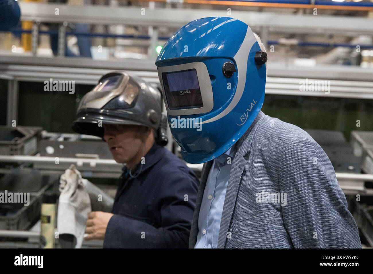 Labour leader Jeremy Corbyn (right) wears a welding helmet during a ...