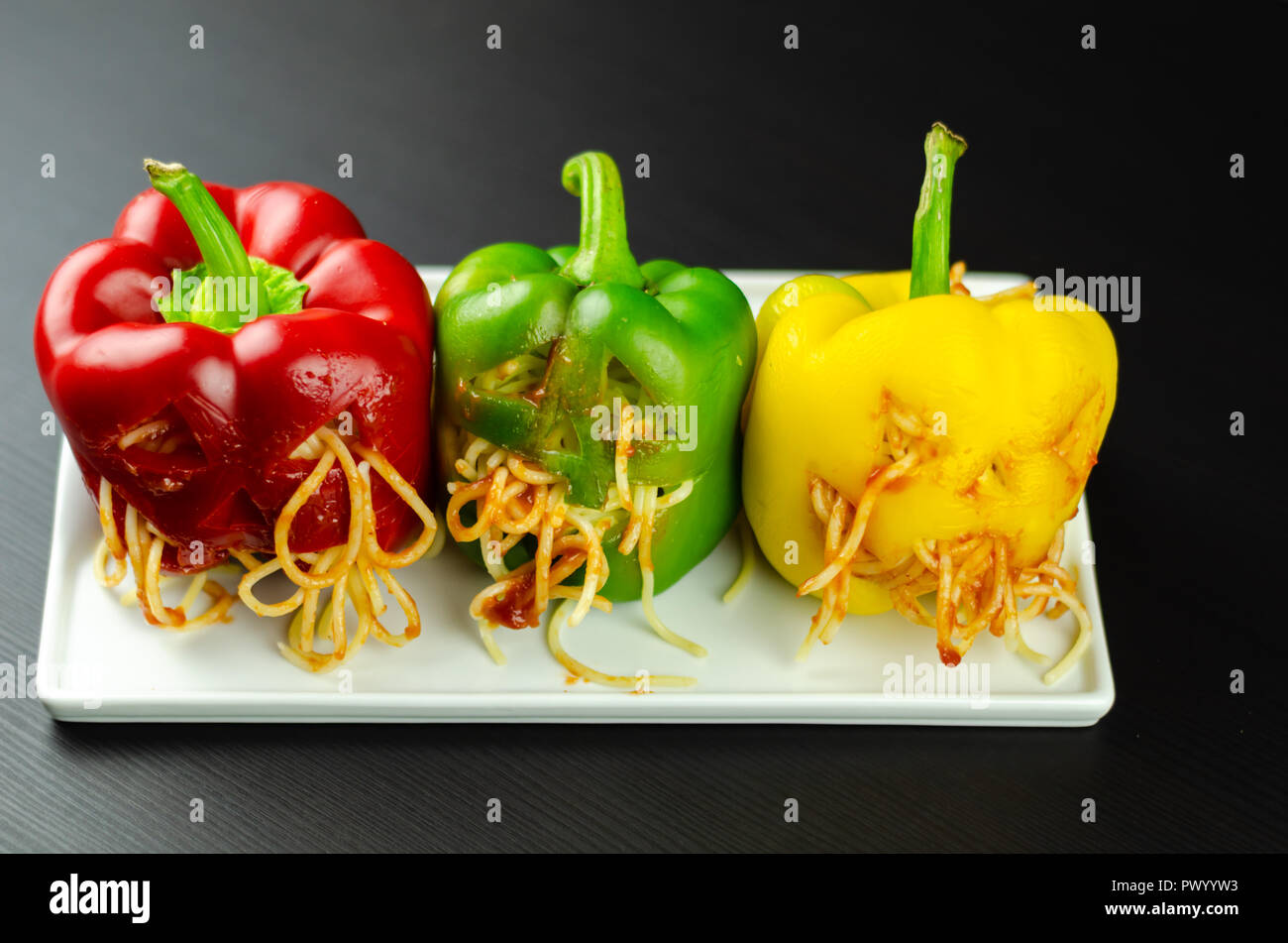 color stuffed peppers with scary cutout faces, halloween party food ...