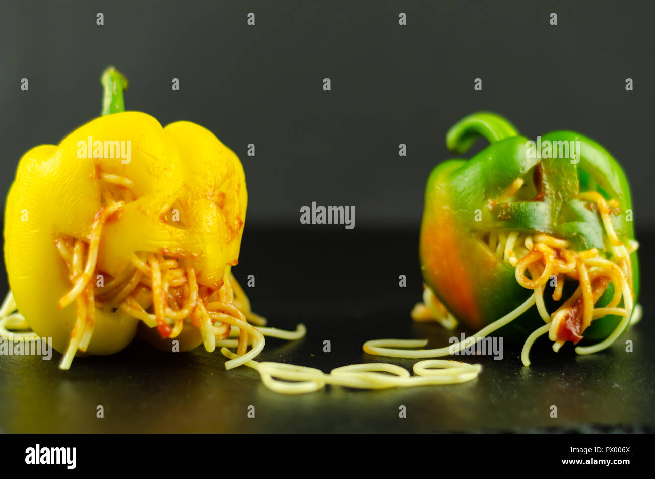 color stuffed peppers with scary cutout faces, halloween party food ...