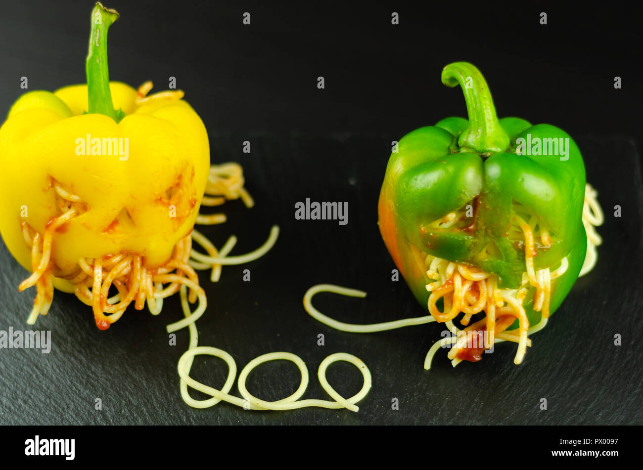 color stuffed peppers with scary cutout faces, halloween party food ...