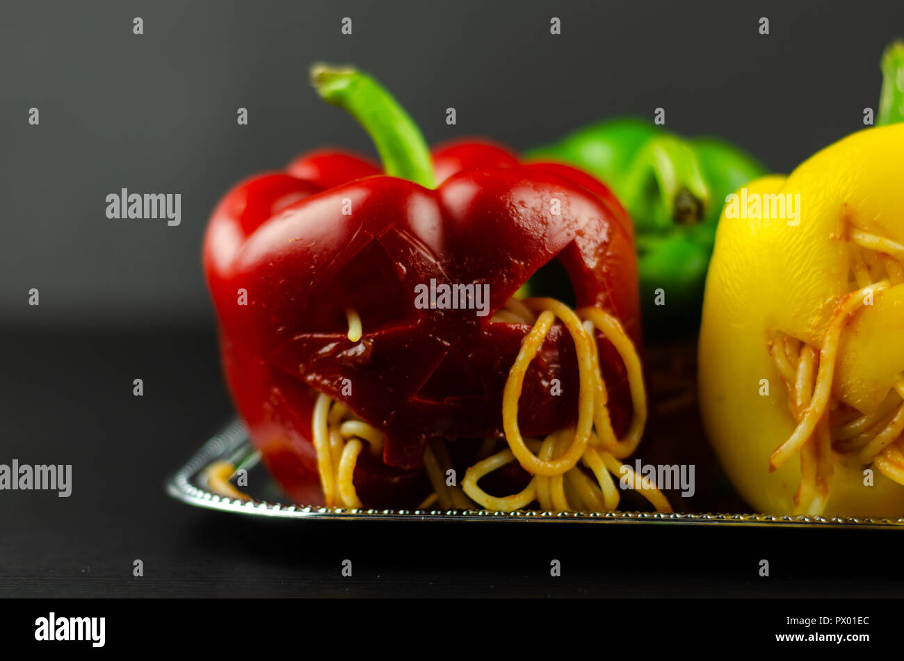 color stuffed peppers with scary cutout faces, halloween party food ...