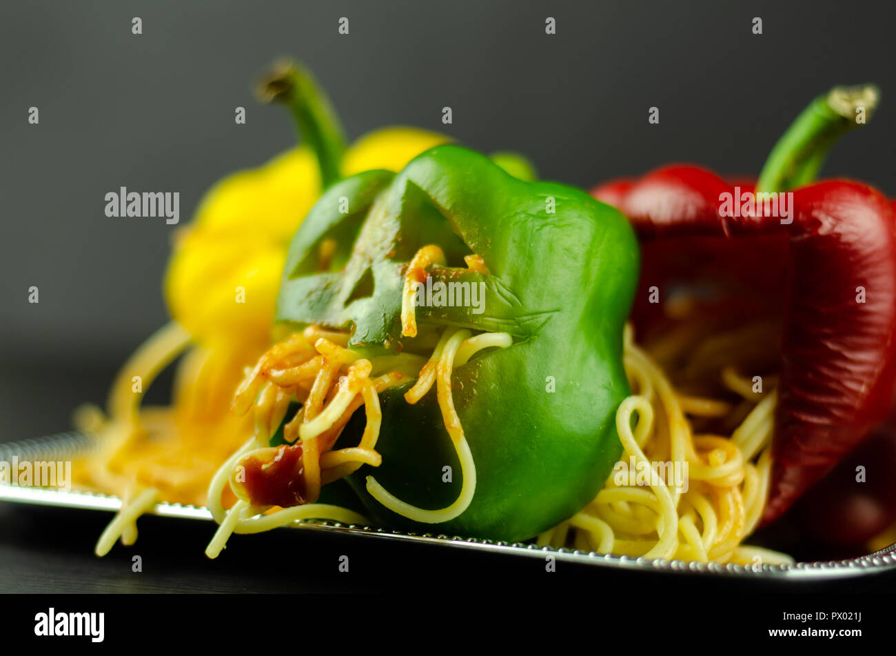 color stuffed peppers with scary cutout faces, halloween party food ...