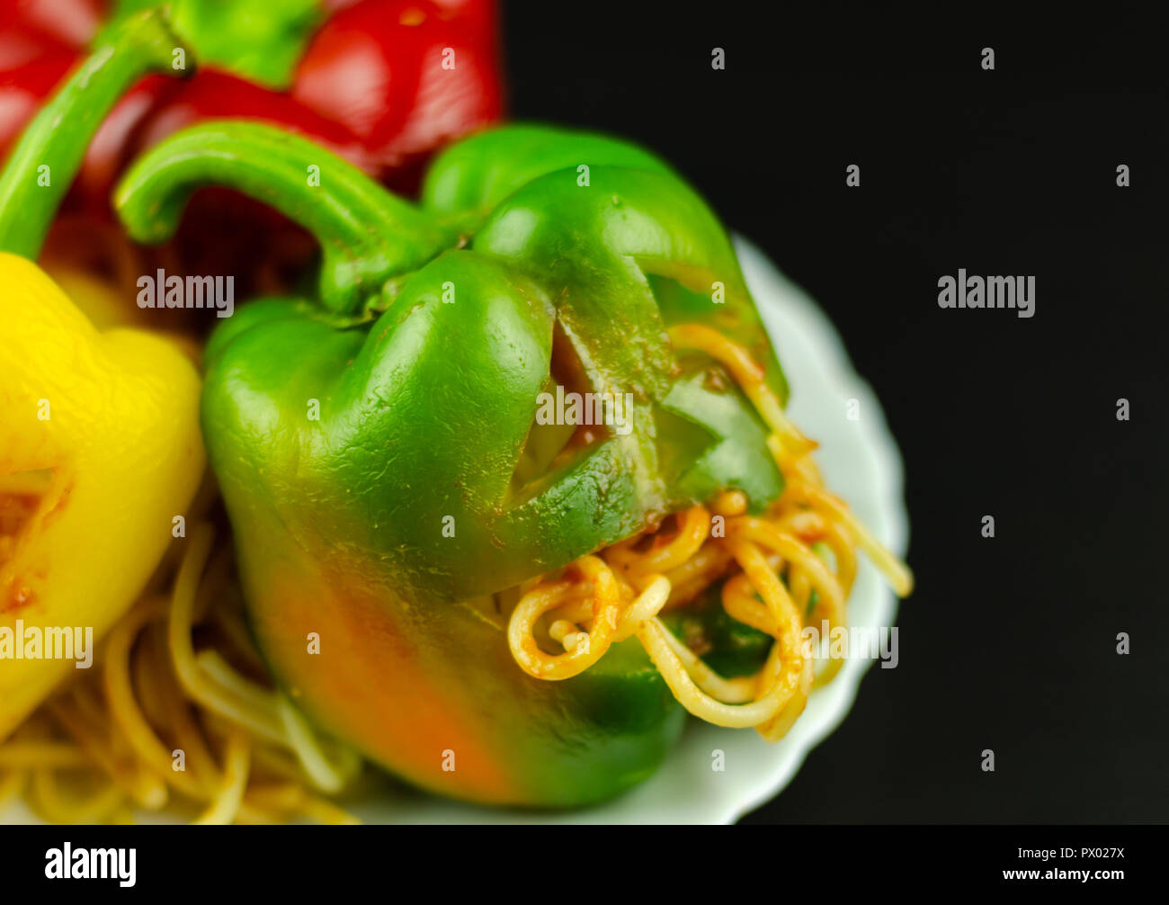 color stuffed peppers with scary cutout faces, halloween party food ...