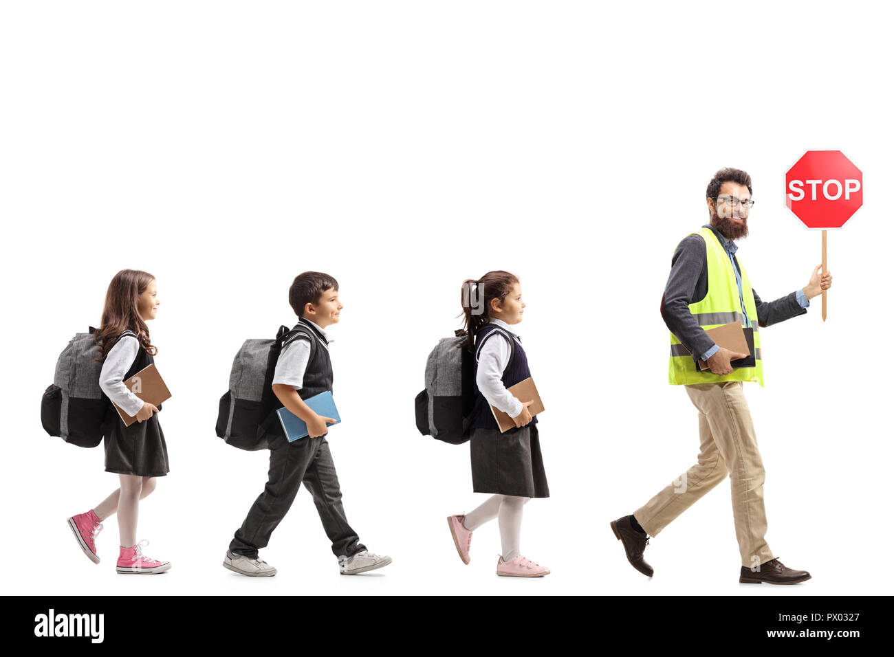 Full length profile shot of schoolchildren walking behind a teacher ...