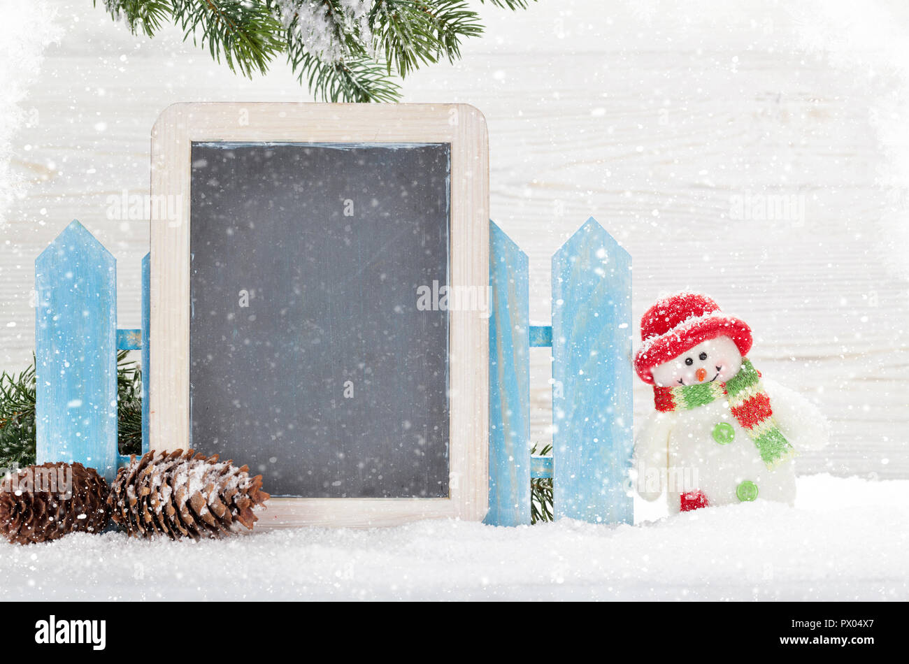 Christmas snowman toy and xmas fir tree branch. With chalkboard for ...