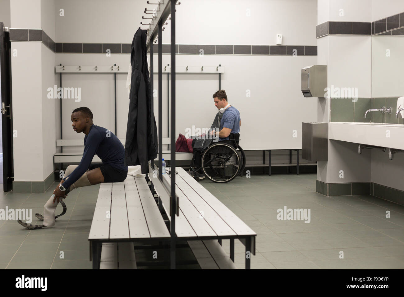 Two disabled athletics relaxing in changing room Stock Photo - Alamy