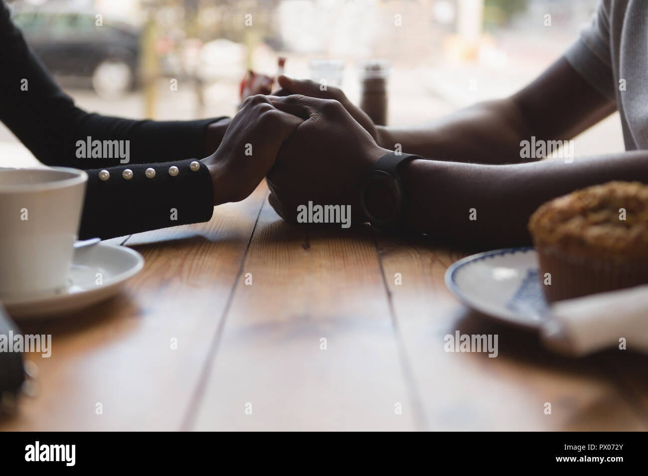 Couple holding hand in cafe Stock Photo - Alamy