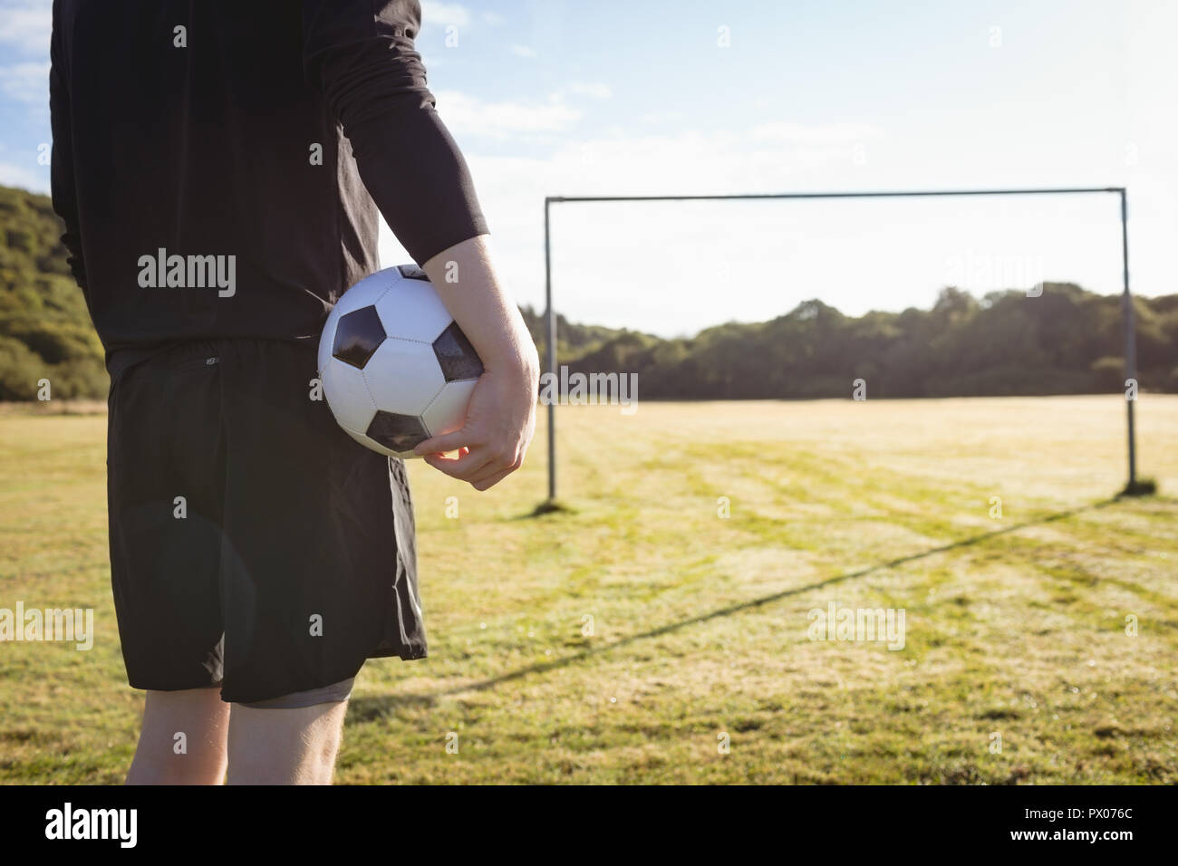 Football player standing with soccer ball in the field Stock Photo - Alamy