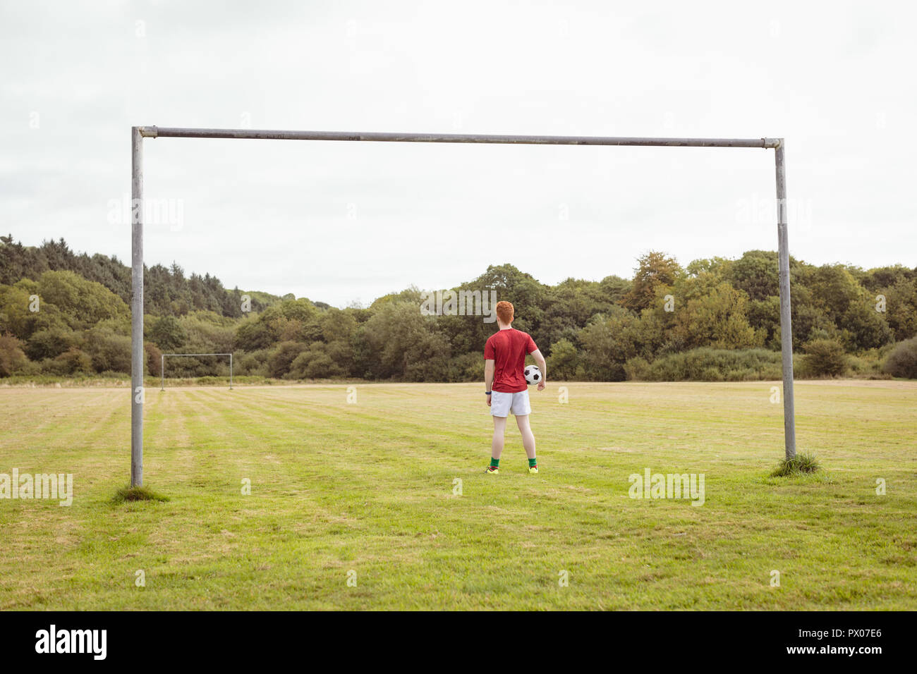 Football player standing with soccer ball in the field Stock Photo - Alamy