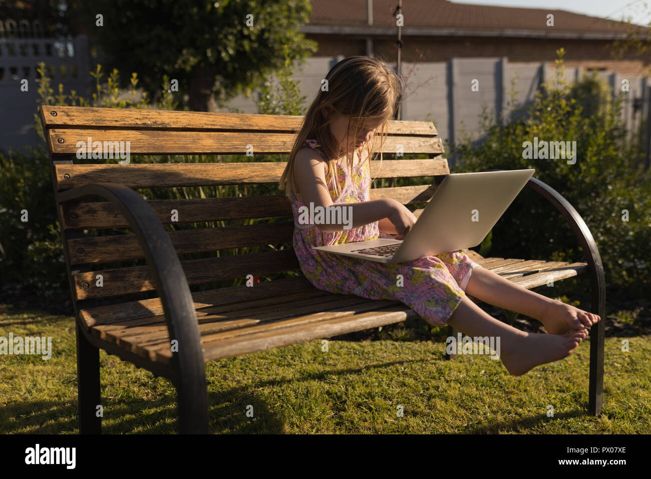 Girl using laptop in the garden Stock Photo - Alamy