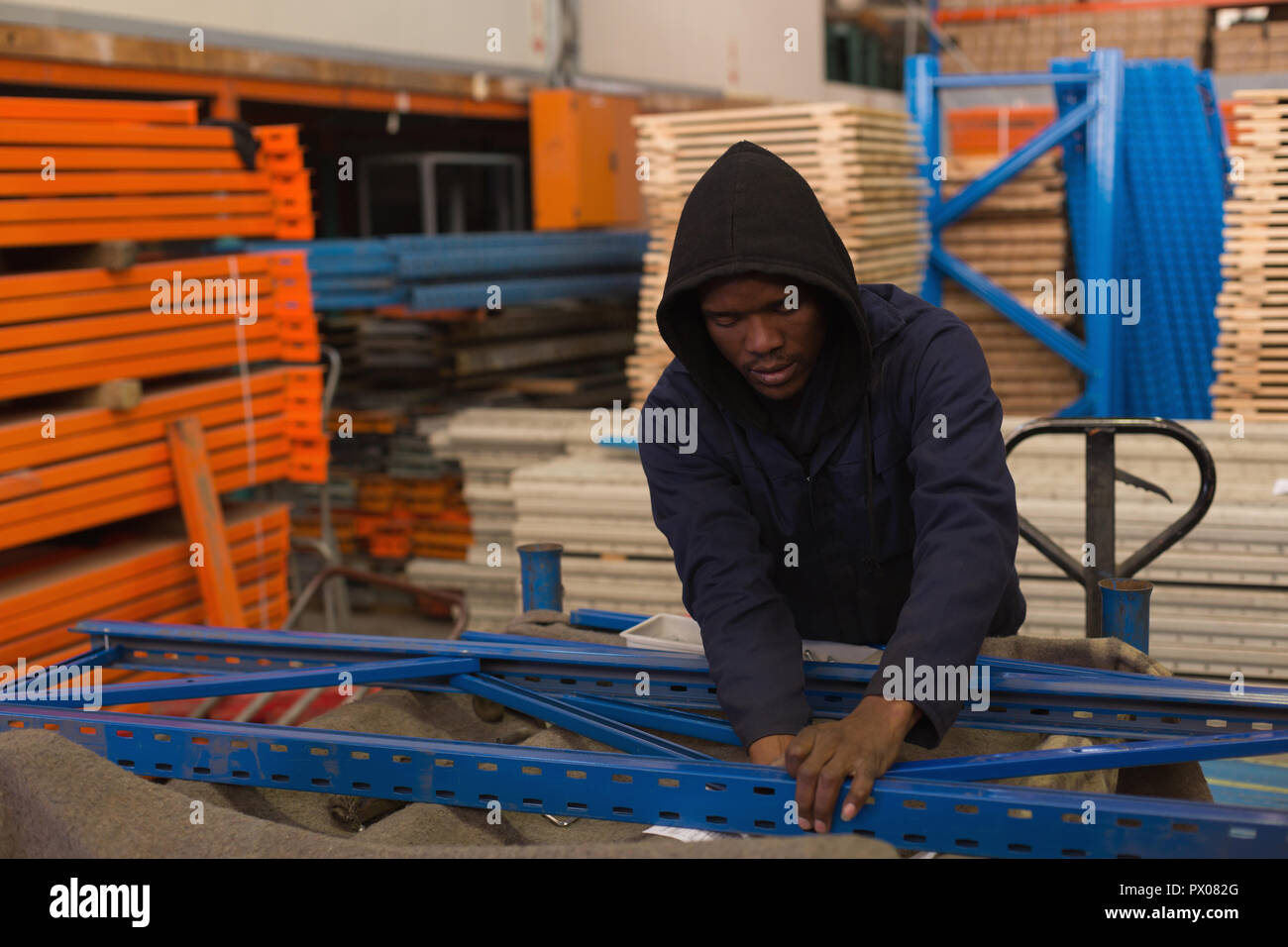 Worker arranging pallet rack Stock Photo - Alamy