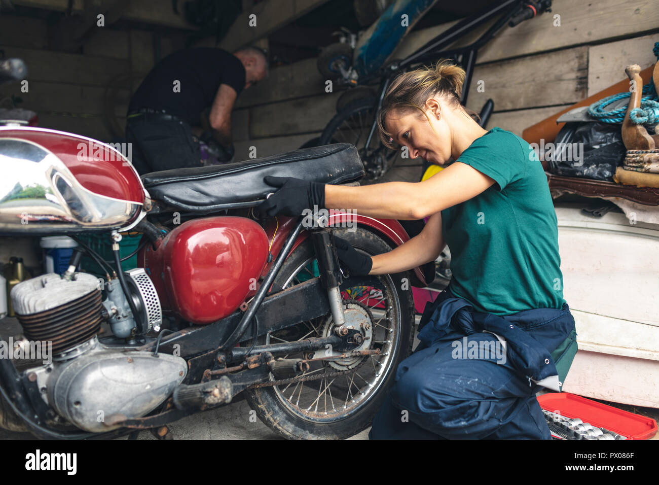 Mechanic repairing motorbike in garage Stock Photo - Alamy