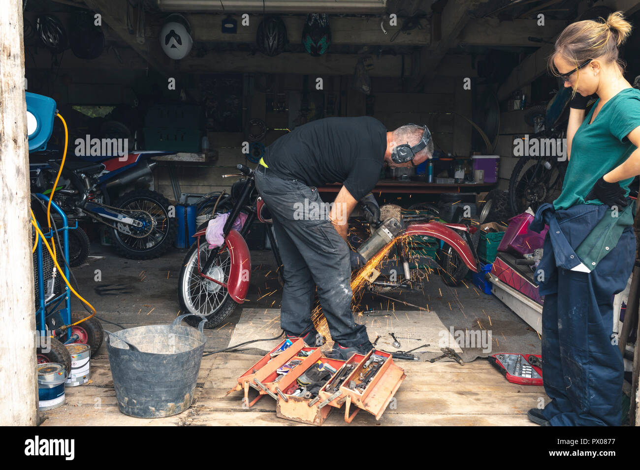 Mechanic using grinder in garage Stock Photo - Alamy