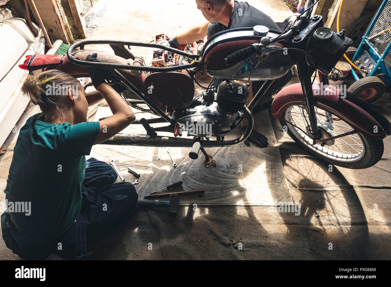 Mechanic repairing motorbike in garage Stock Photo - Alamy