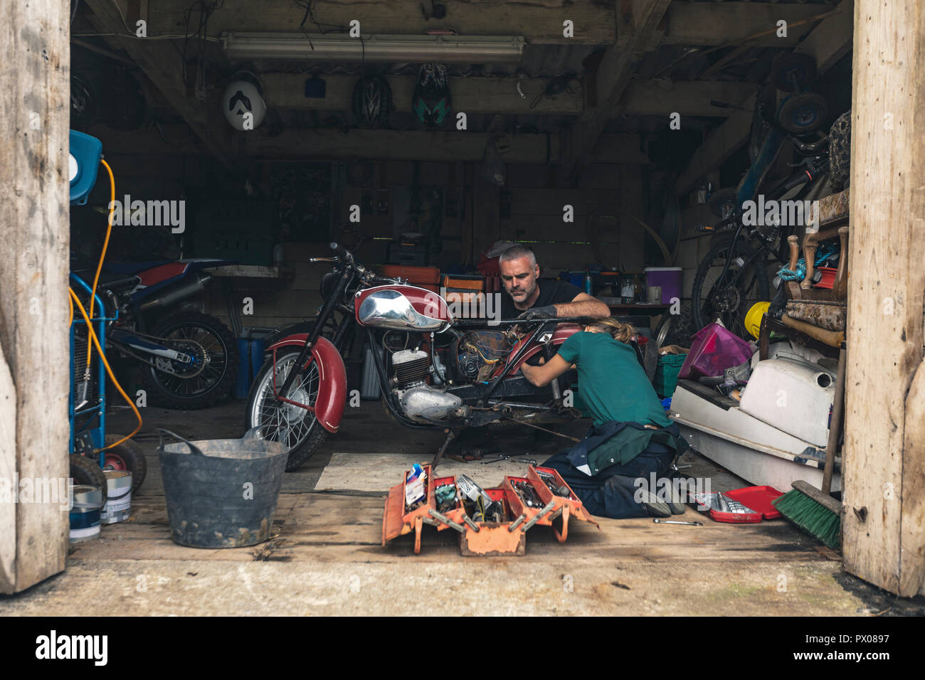 Mechanic repairing motorbike in garage Stock Photo - Alamy