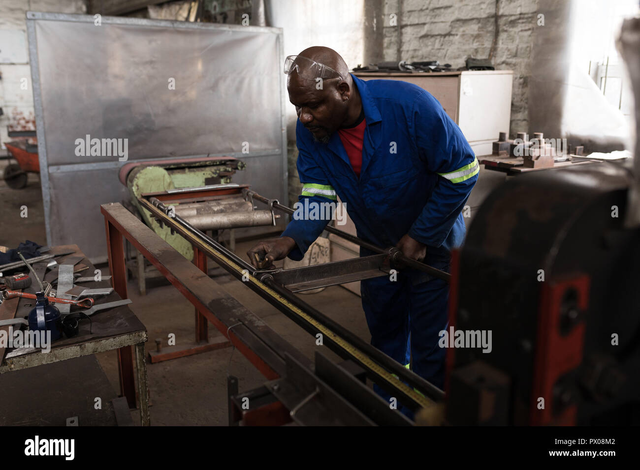 Blacksmith measuring metal rod in workshop Stock Photo - Alamy