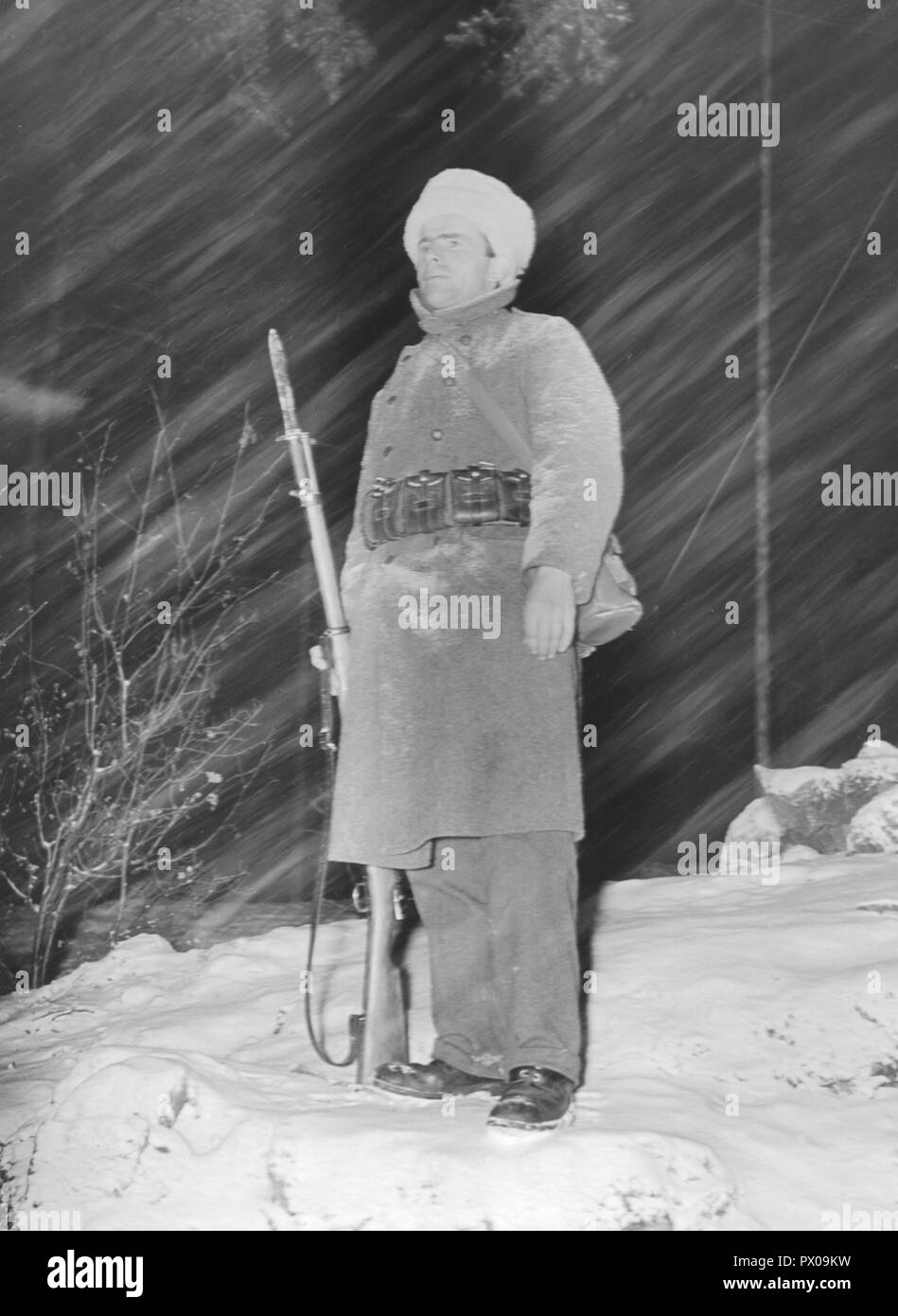 Swedish army during WW2. A soldier is standing in the snowfall och ...