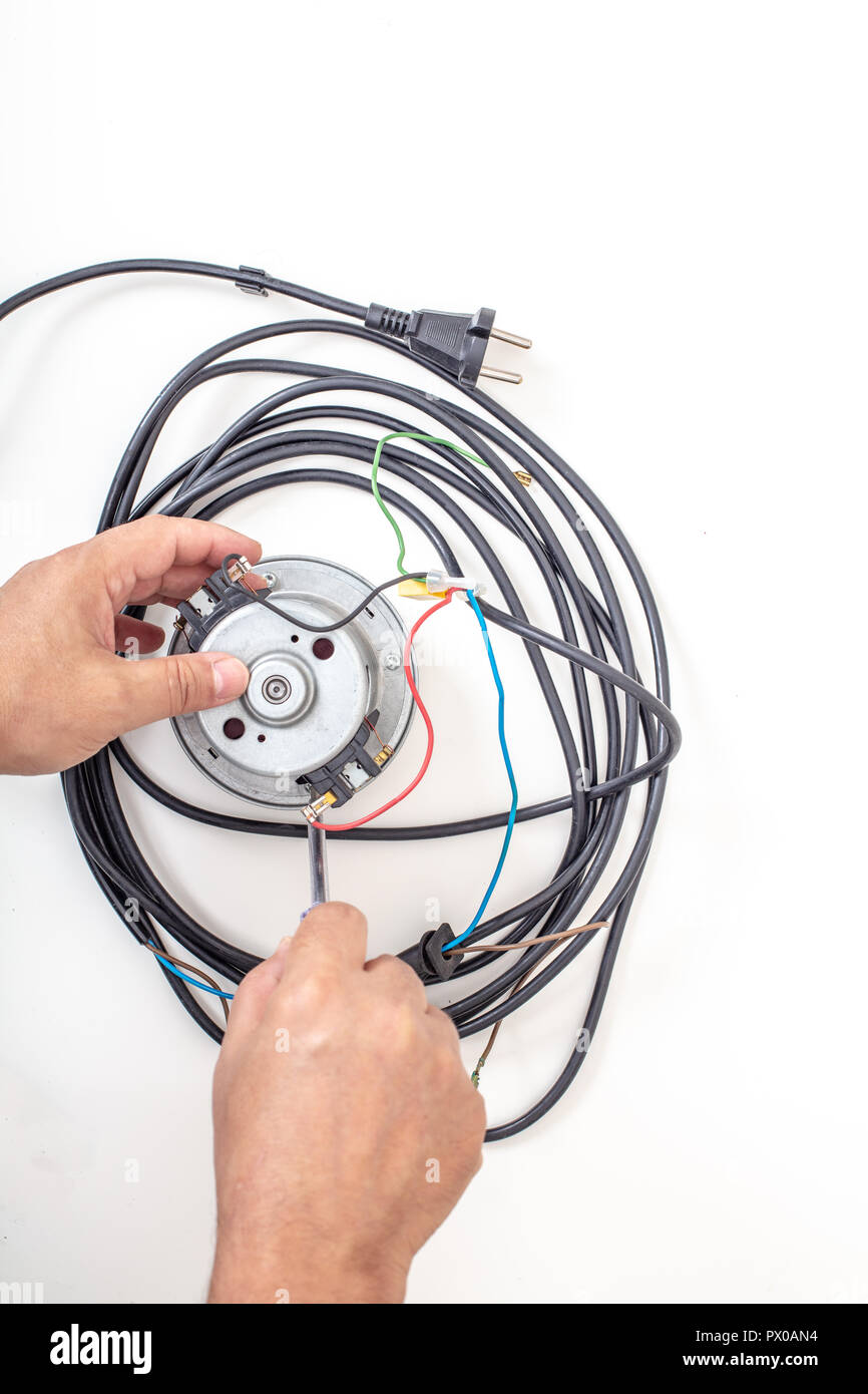 Vacuum cleaner motor with cord and srewdriver on a white background top ...