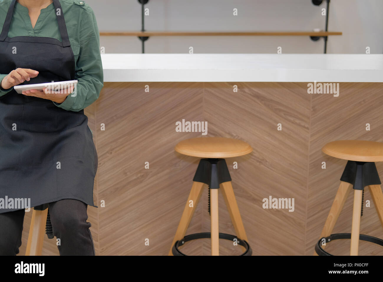 business owner wearing apron holding tablet at counter bar. man using ...