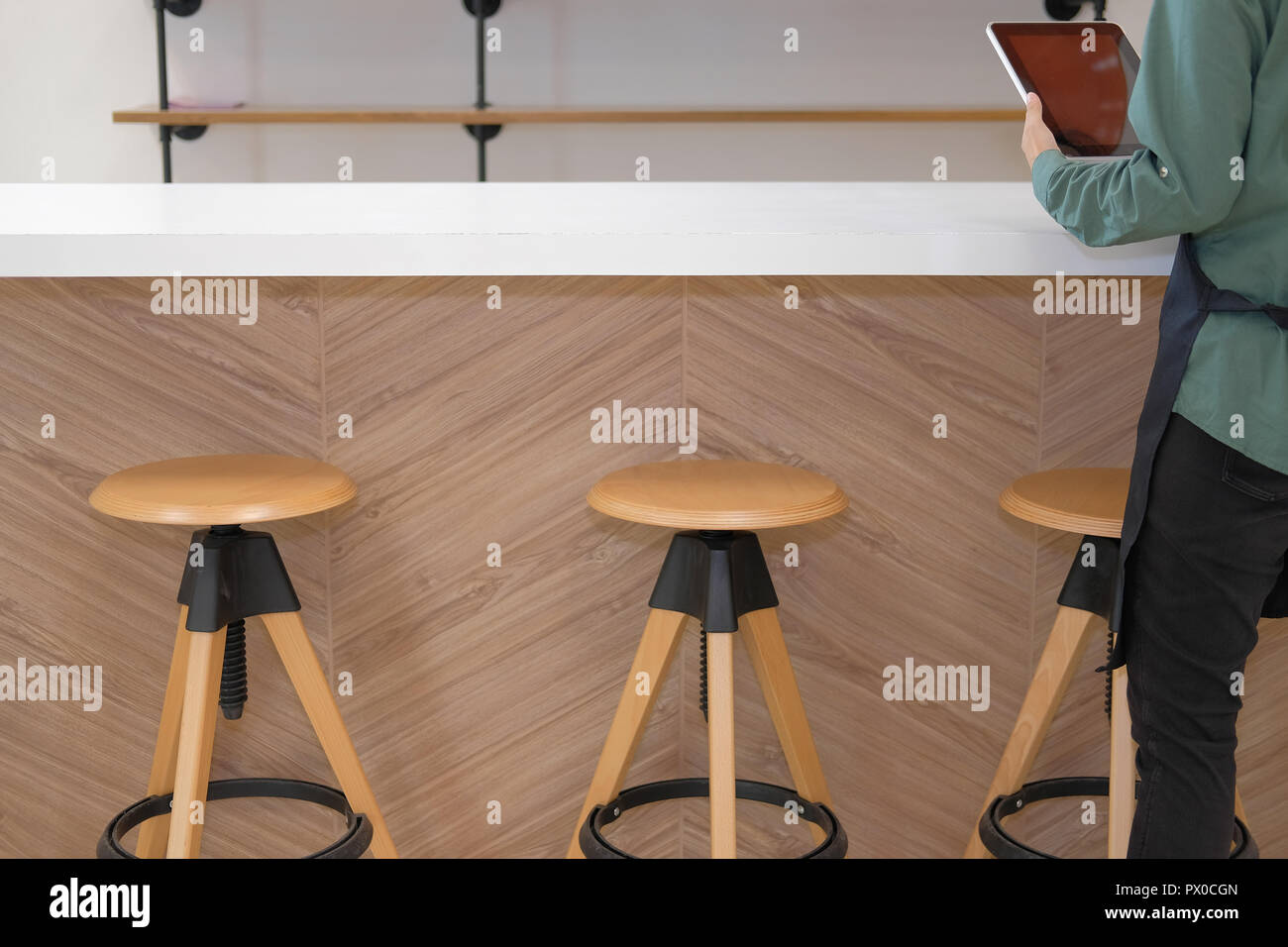 business owner wearing apron holding tablet at counter bar. man using ...