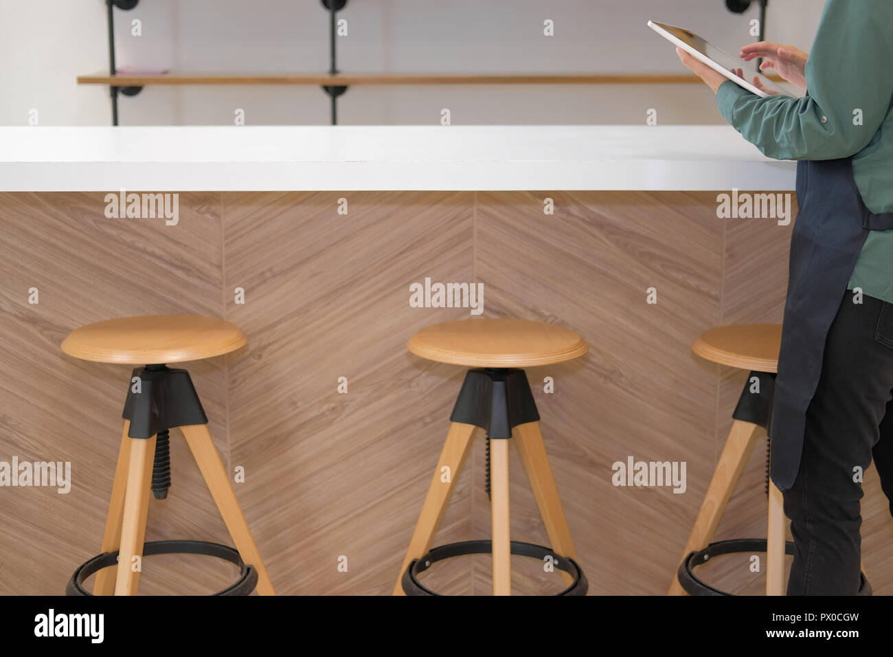 business owner wearing apron holding tablet at counter bar. man using ...