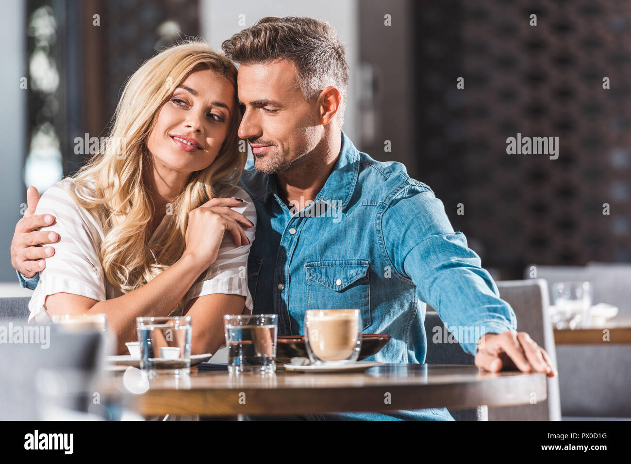 happy tender couple hugging at table in cafe Stock Photo - Alamy