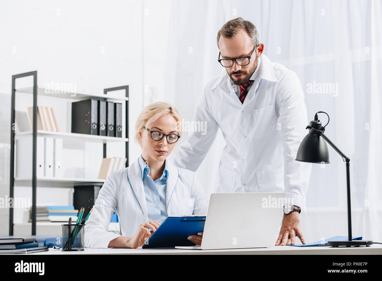 portrait of physiotherapists in white coats and eyeglasses working ...