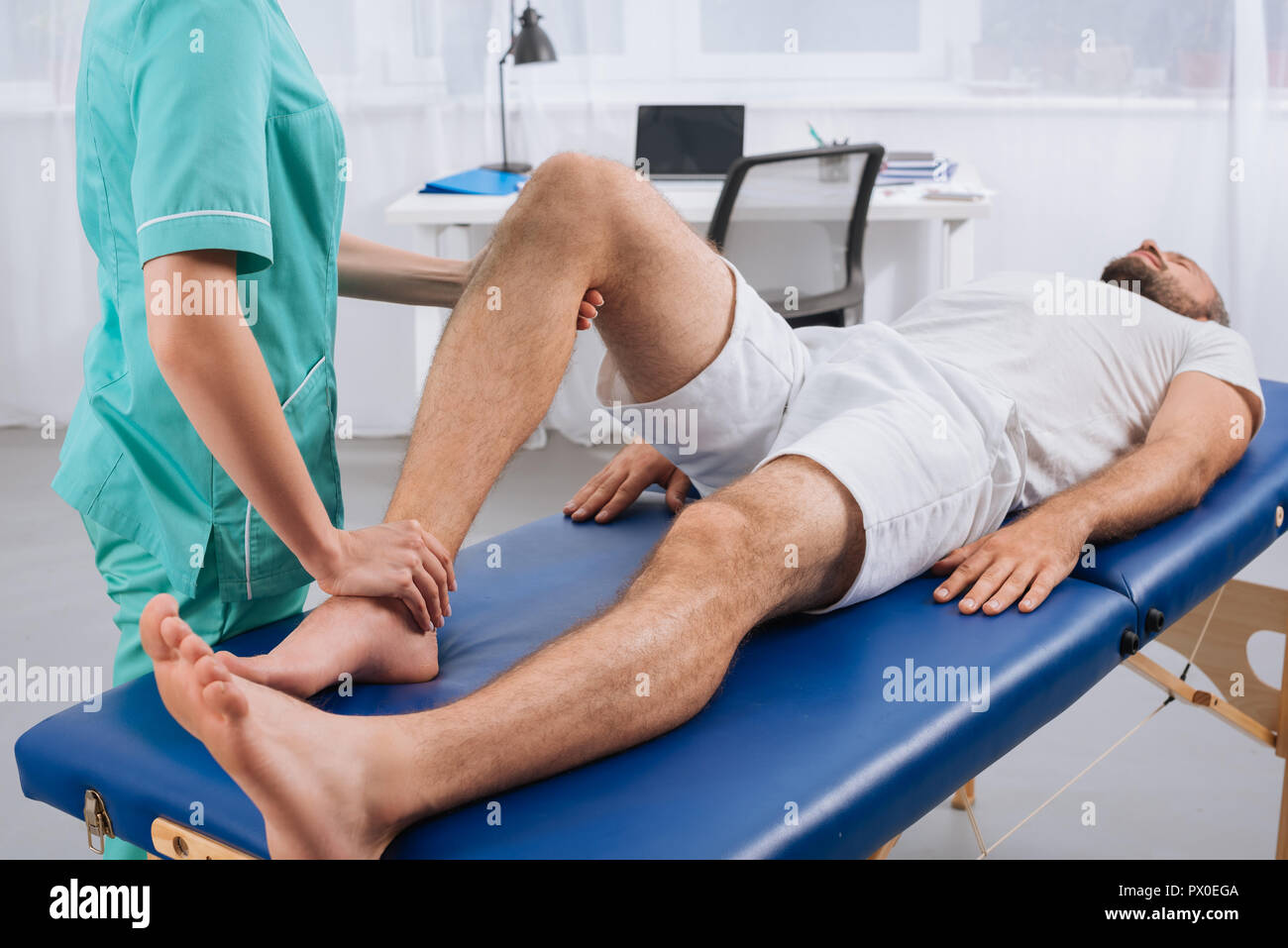 partial view of female massage therapist doing massage to patient on ...