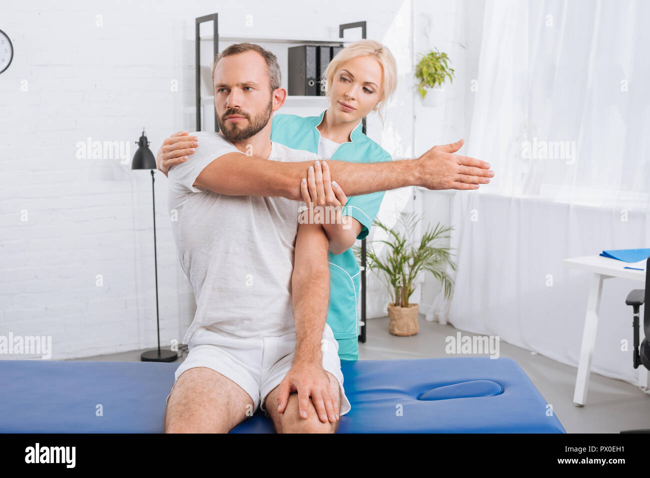 Doctor stretching woman arm hi-res stock photography and images - Alamy