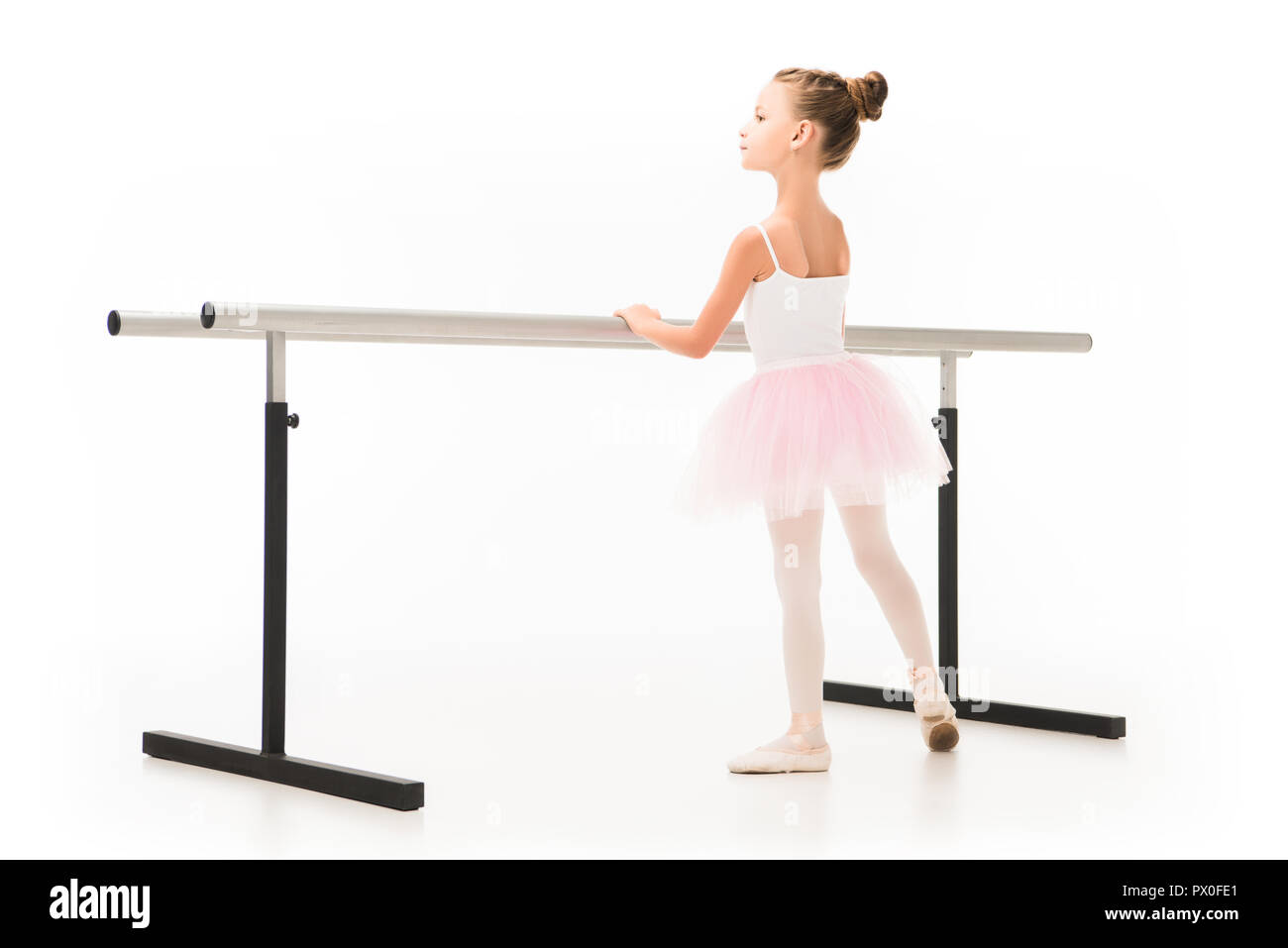 rear view of beautiful little ballerina in tutu exercising at ballet ...