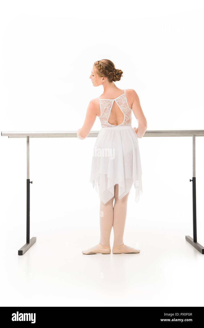 rear view of elegant ballerina in tutu and pointe shoes practicing at ...