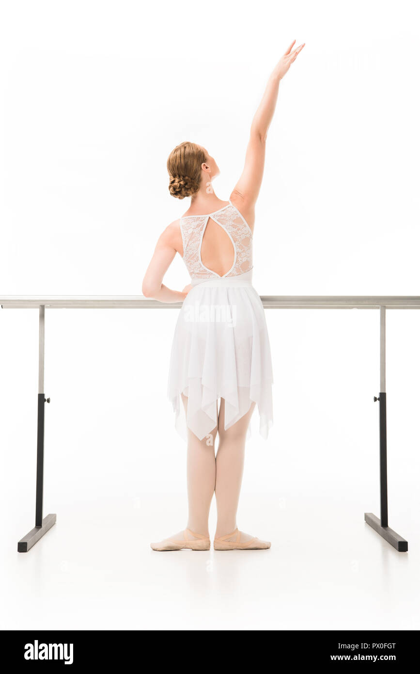 rear view of ballerina in tutu and pointe shoes exercising at ballet ...