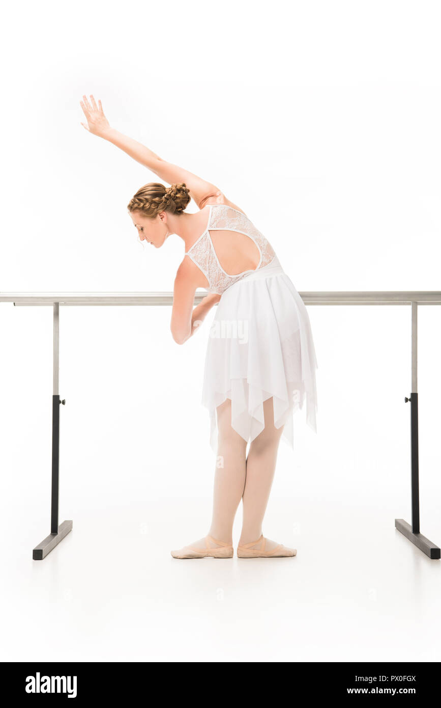 rear view of ballerina in tutu and pointe shoes practicing at ballet ...