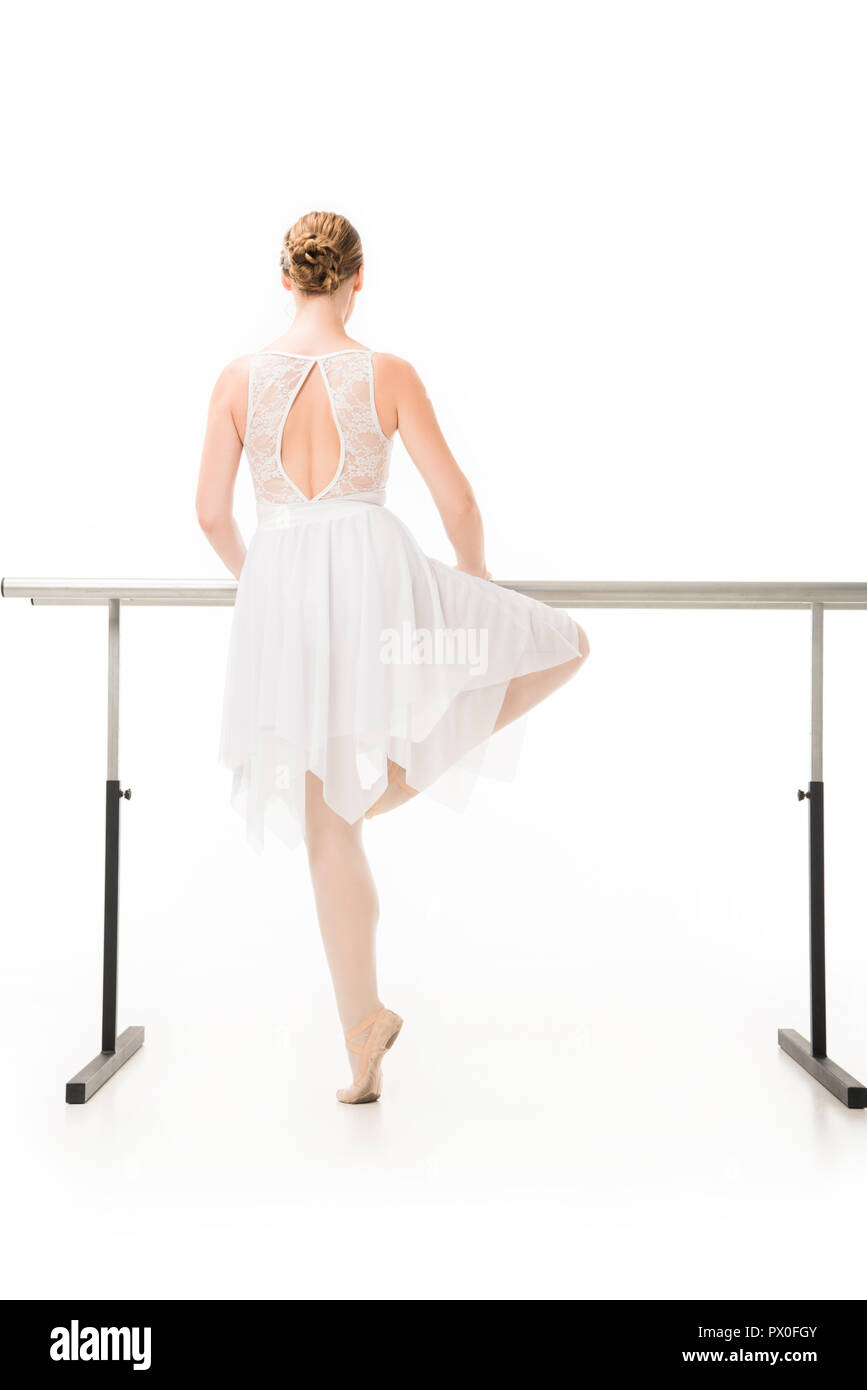 back view of ballerina in tutu and pointe shoes practicing at ballet ...