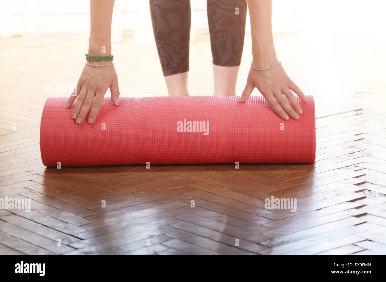 Female hands unrolling yoga mat before workout exercise. Healthy ...