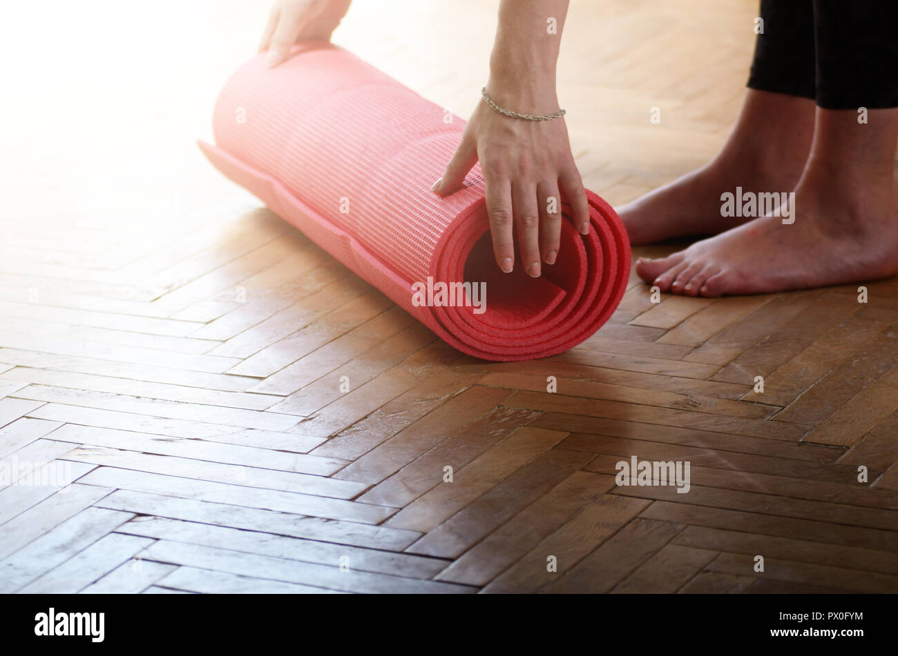 Female hands unrolling yoga mat before workout exercise. Healthy ...