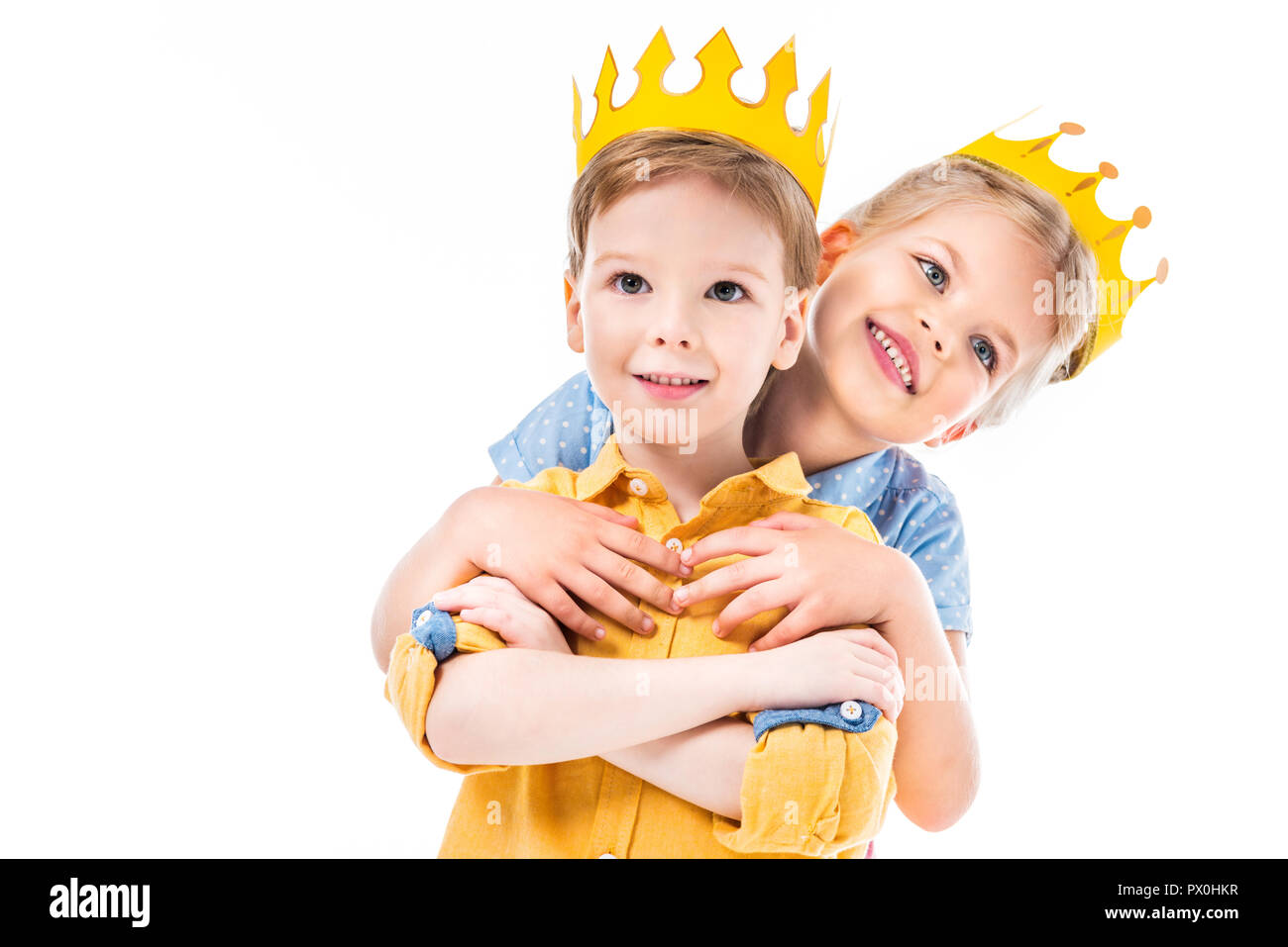 sister hugging brother, kids in yellow paper crowns, isolated on white ...