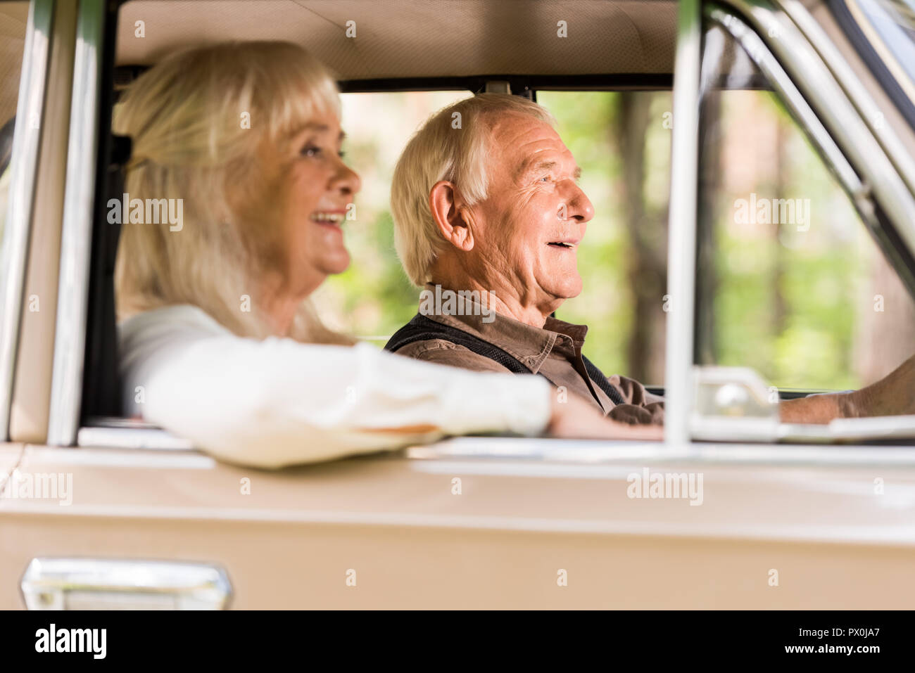 side view of handsome senior couple driving beige vintage car Stock ...