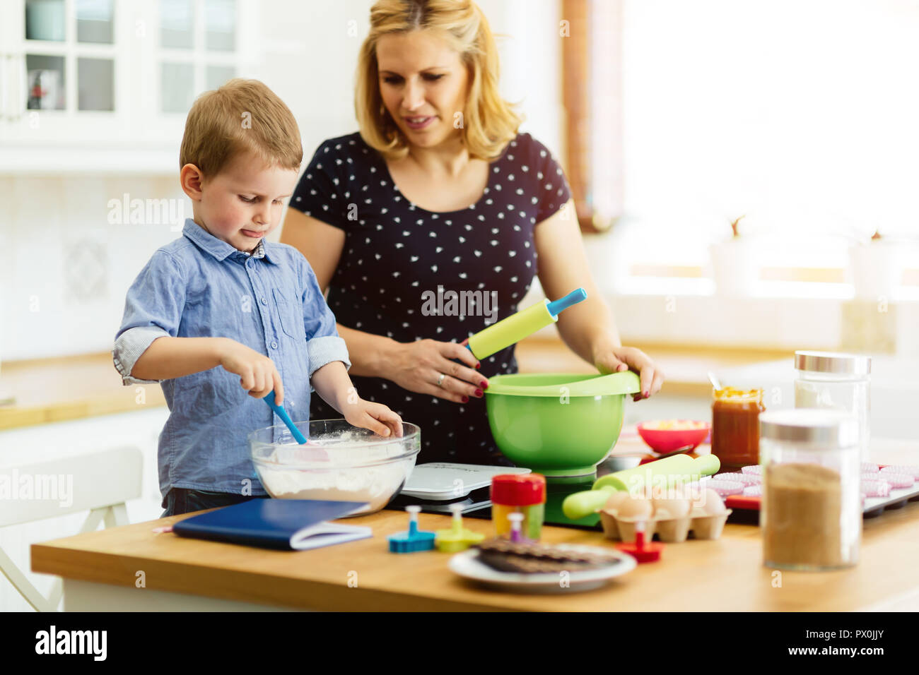 Beautiful child and mother baking Stock Photo - Alamy