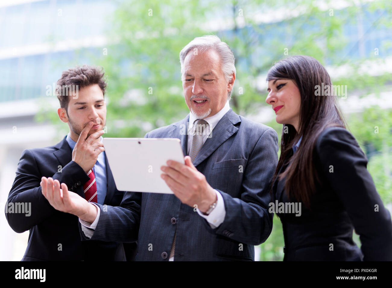 Business people using a tablet outdoor Stock Photo - Alamy