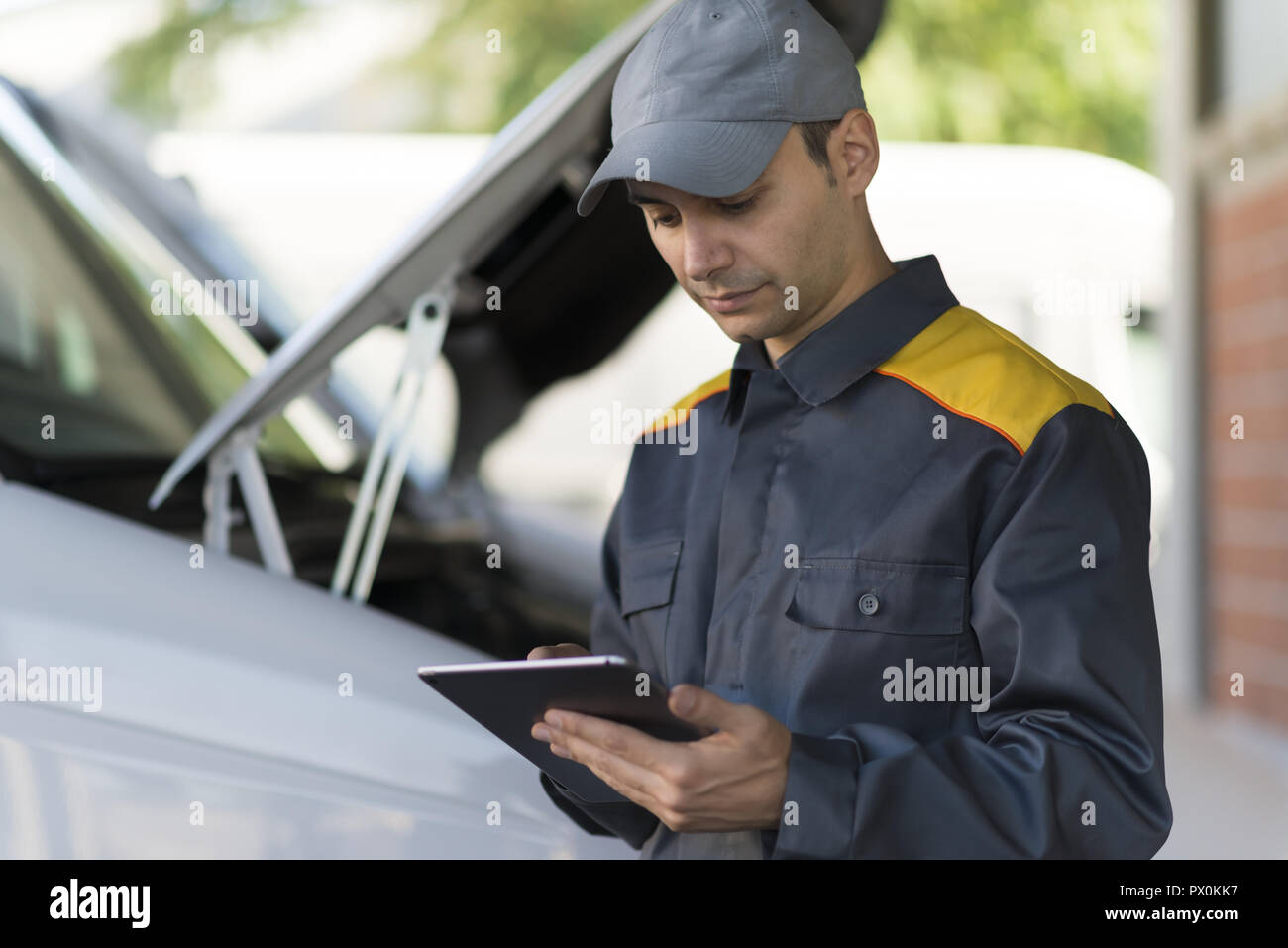 Mechainc using a tablet in front of a van Stock Photo - Alamy