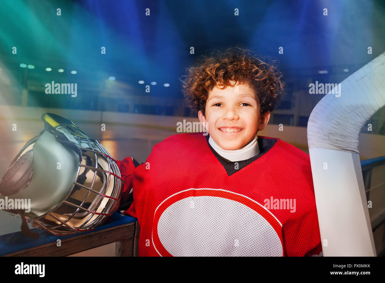Happy hockey player standing next to the boards Stock Photo - Alamy