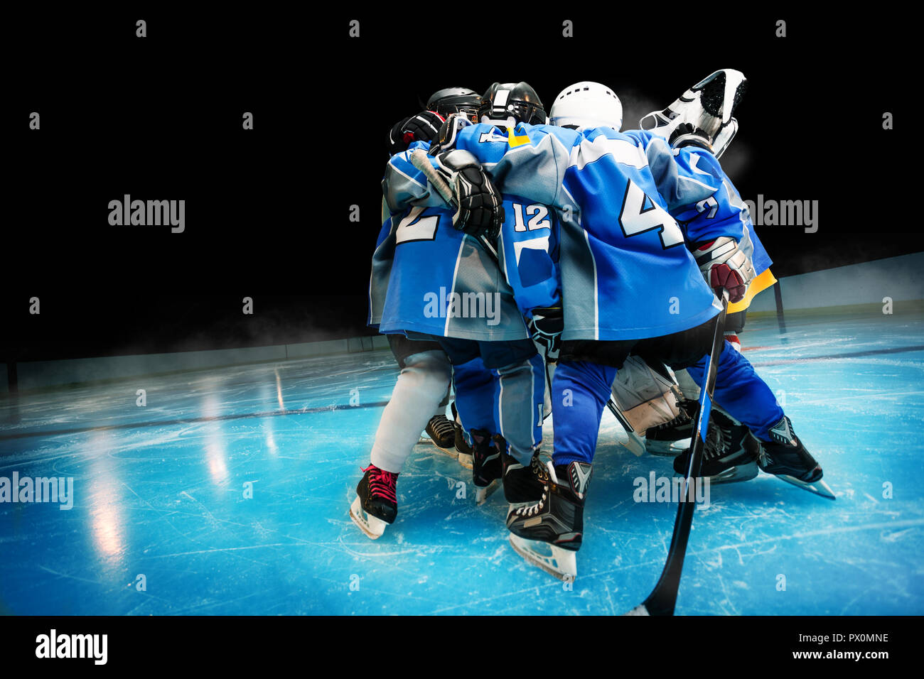 Hockey team standing in circle on ice rink Stock Photo - Alamy