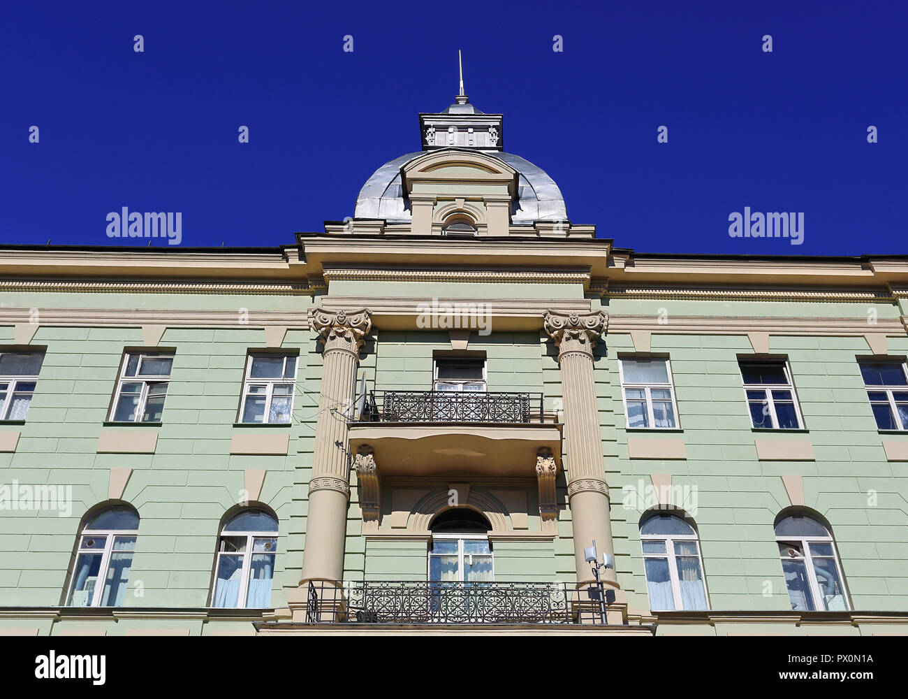 Aged buildings wall with columns and decorative curly turret on the ...