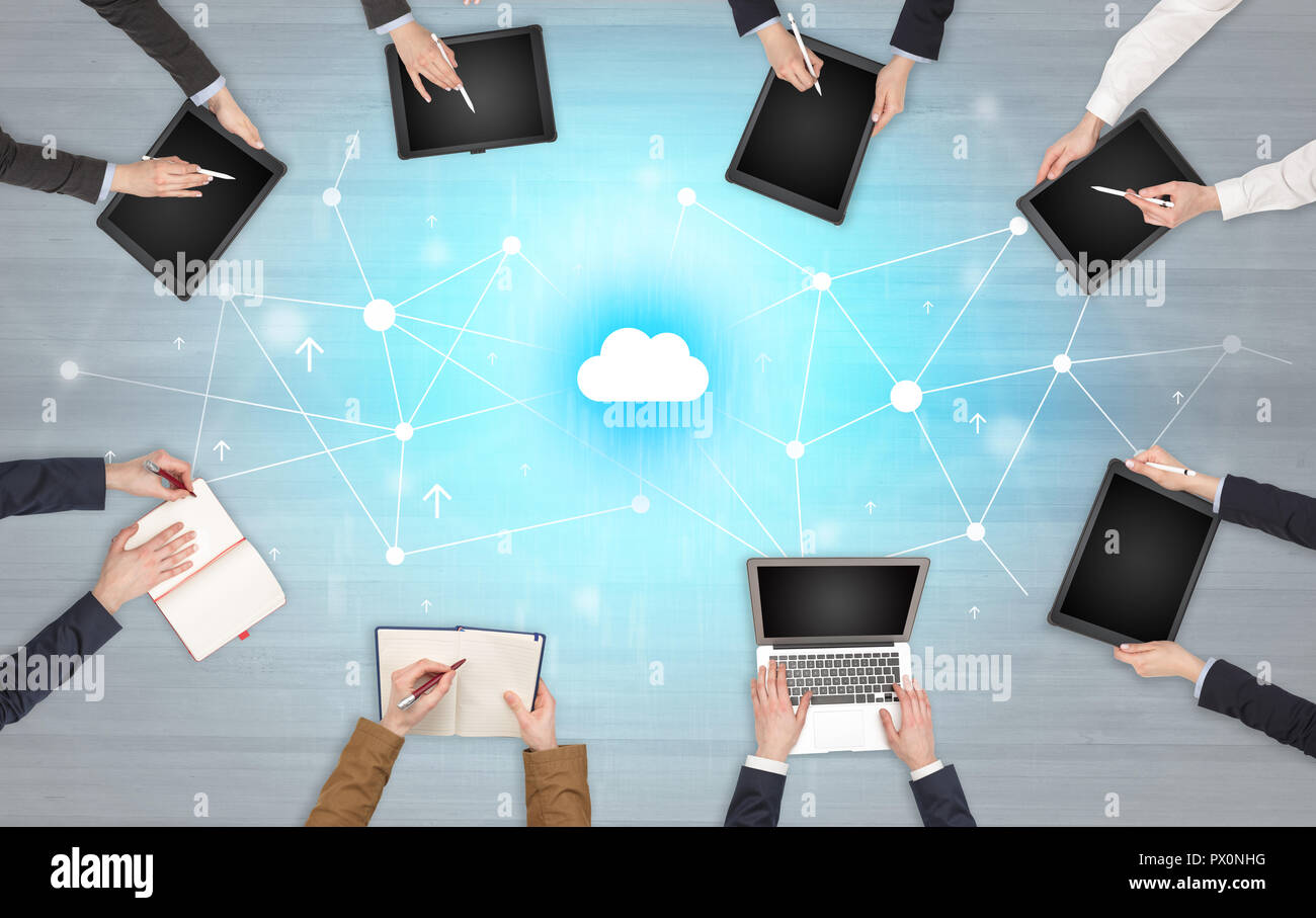 Group of people with devices in hands working in team on tablets ...