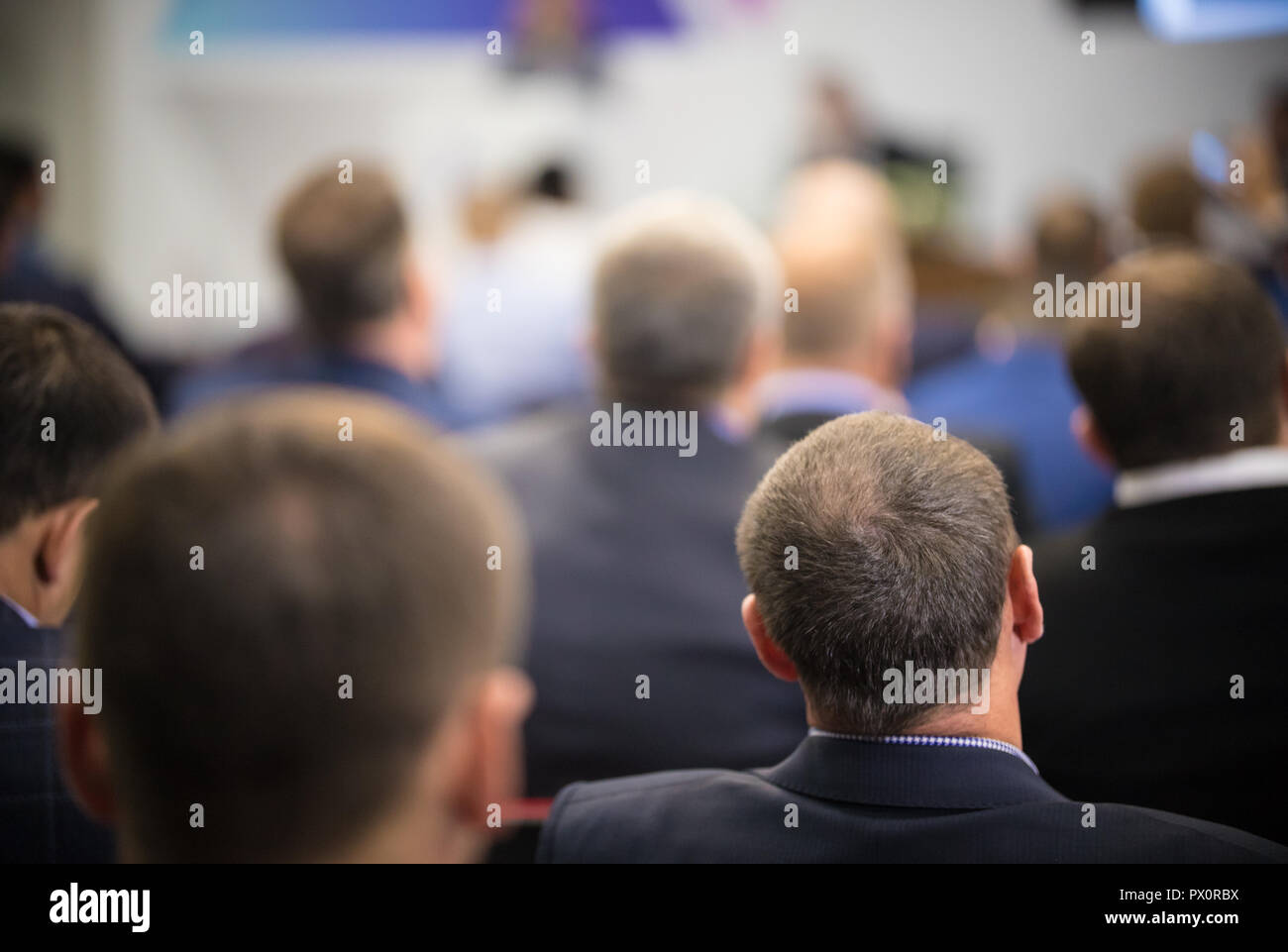 Mature men sitting rear at the business conference. Back view Stock ...