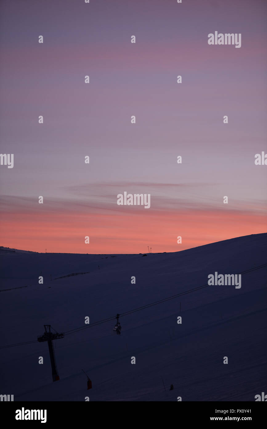 Winter ski holiday in snowy mountains with beautiful glowing red sun ...