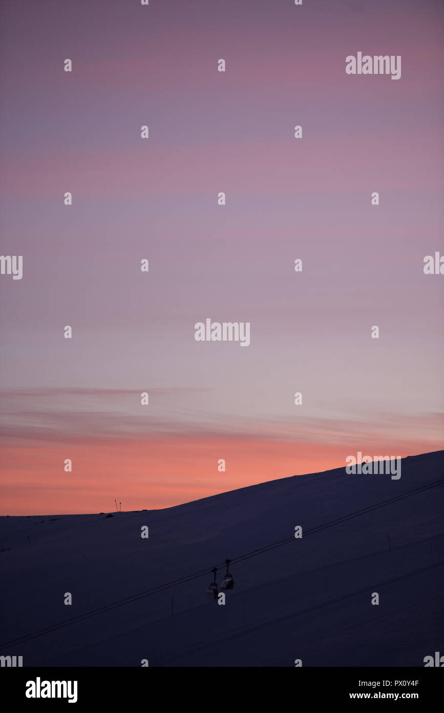 Winter ski holiday in snowy mountains with beautiful glowing red sun ...