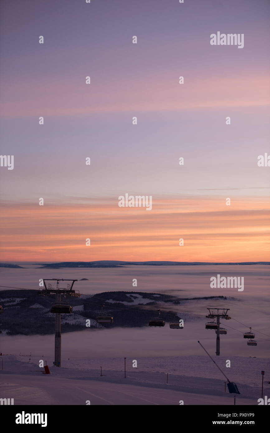 Winter ski holiday in snowy mountains with beautiful glowing red sun ...